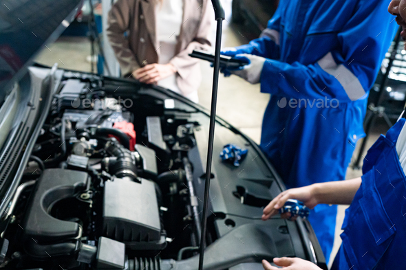 Mechanic in blue overalls checking serviceability of car engine Stock ...