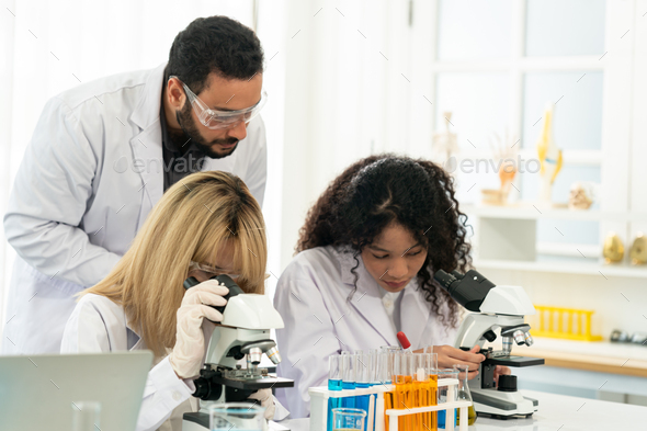 People working in the laboratory, Using Magnifying Glass on Microscope ...