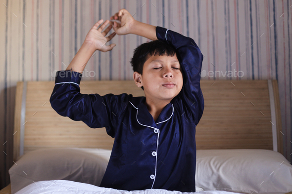 Cute boy wake up in the morning stretching hand rise up Stock Photo by ...