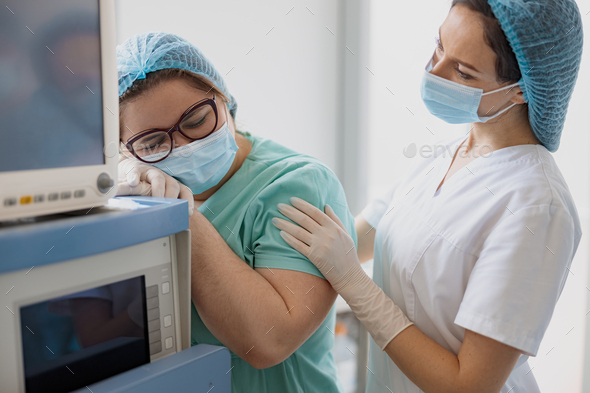 Tired nurses after difficult operation support each other in operating ...
