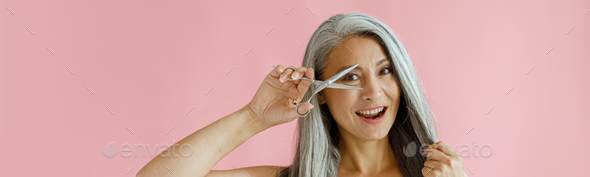 Happy middle aged woman with long hoary hair looks through open ...