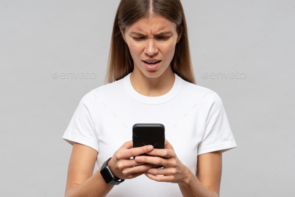 Indignant irritated woman upset with broken phone app isolated on gray ...