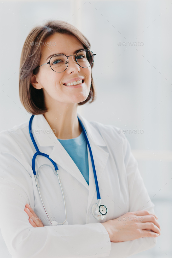 Close up portrait of short haired female general practitioner stands ...