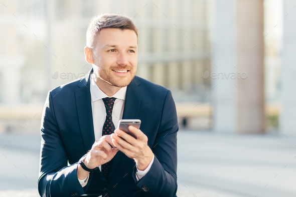 Smiling male manager with appealing look, dressed formally, chats with ...