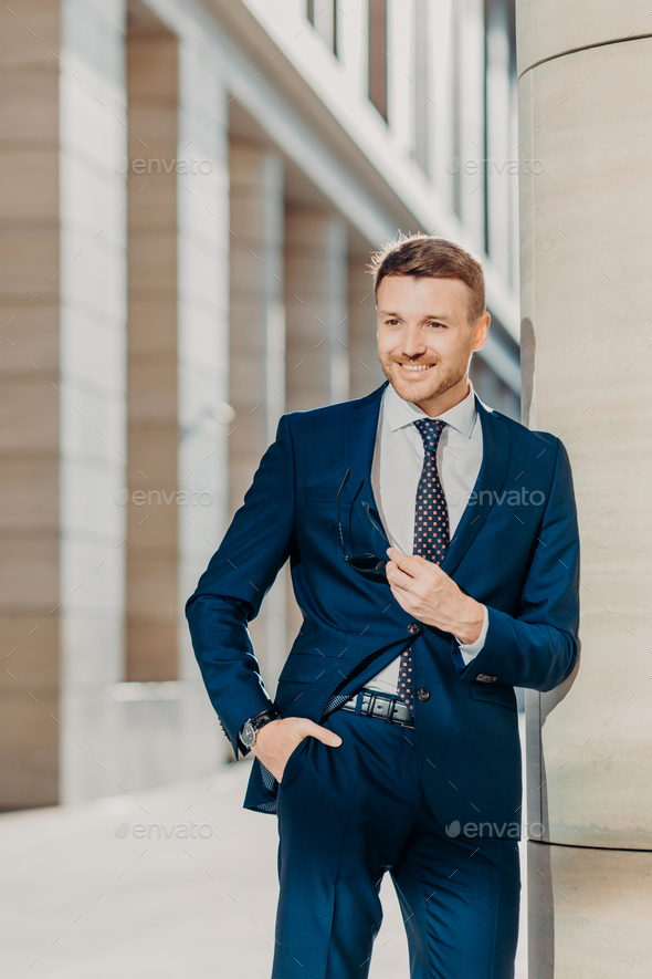 Vertical shot of handsome male with appealing appearance, dressed in ...
