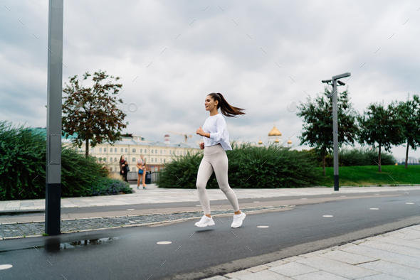 Sportswoman jogging on walkway in park Stock Photo by GaudiLab | PhotoDune