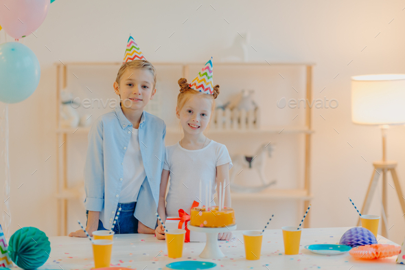 Glad boy and his small ginger sister dressed in festive clothes, party ...