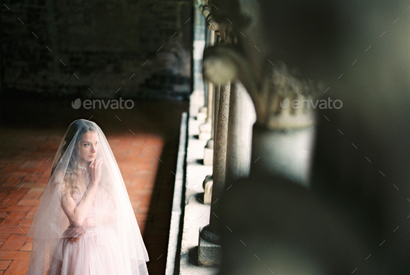 Bride in a veil stands on the terrace. Top view Stock Photo by Nadtochii