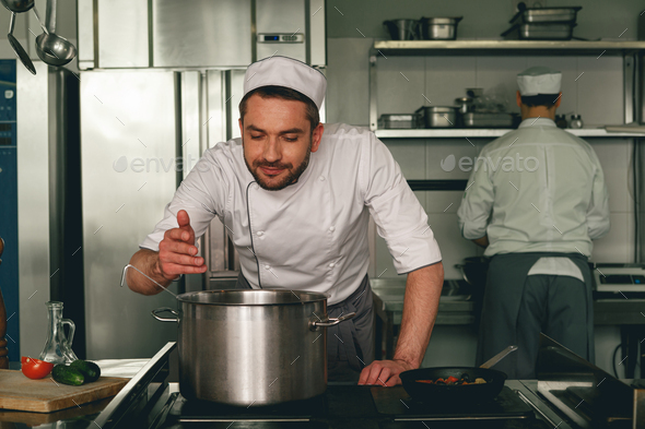 Man japanese restaurant chef cooking in the kitchen and inhaling aroma ...