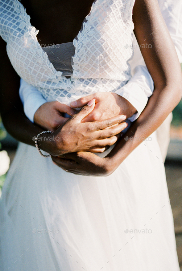 Groom hugs bride from behind. Close-up Stock Photo by Nadtochii | PhotoDune