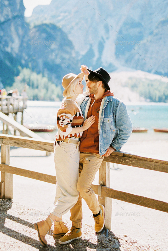 Woman hugs man leaning against a wooden fence. Lake Braies, Italy Stock ...
