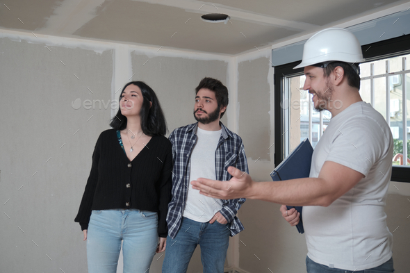 Architect shows new apartment in construction to young couple ...