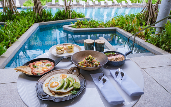 Luxury breakfast by a swimming pool during vacation. Breakfast with ...