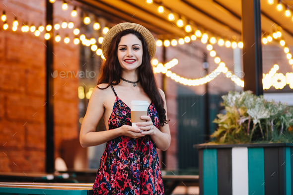 Positive woman with dark hair and appealing face, wearing summer dress ...