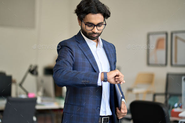 Busy indian business man checking time looking at watch in office ...