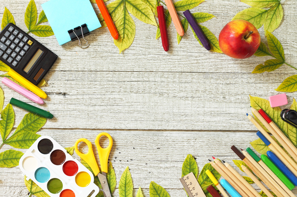 Back to school. Table with autumn leaves, apple and school supplies ...