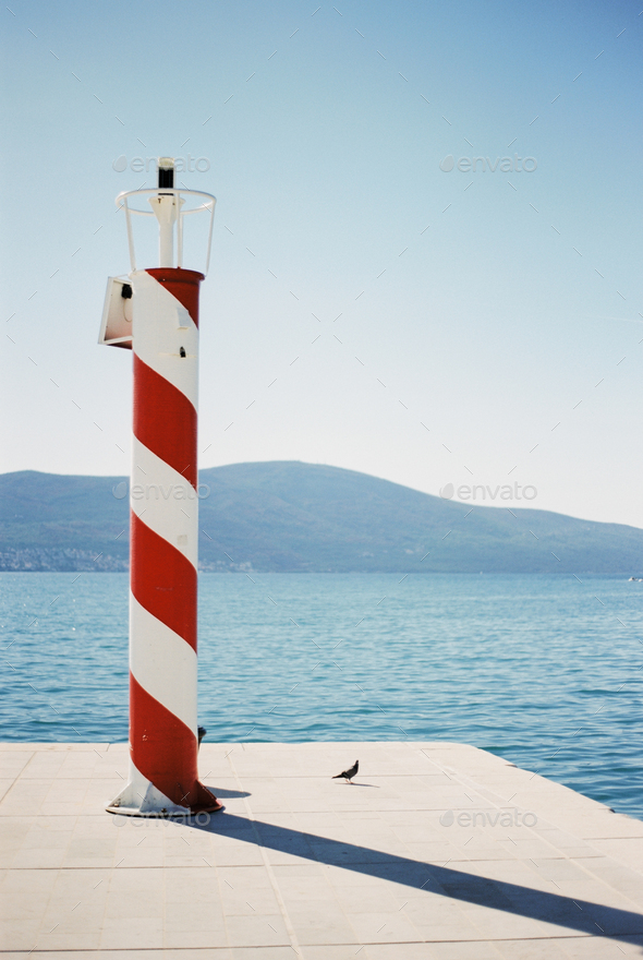 Solar powered automatic lighthouse at the pier in Porto. Montenegro ...