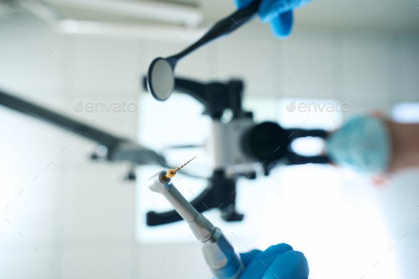 Professional endodontist performing tooth nerve removal under ...
