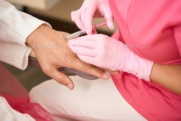 Moment of introduction of beauty injection into arm of man Stock Photo ...