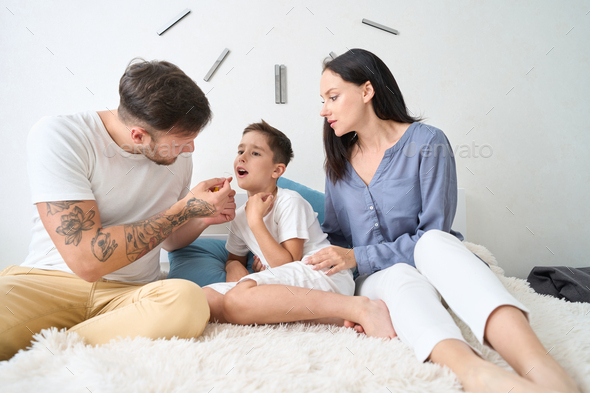 Caring parents take care of their son during illness Stock Photo by ...