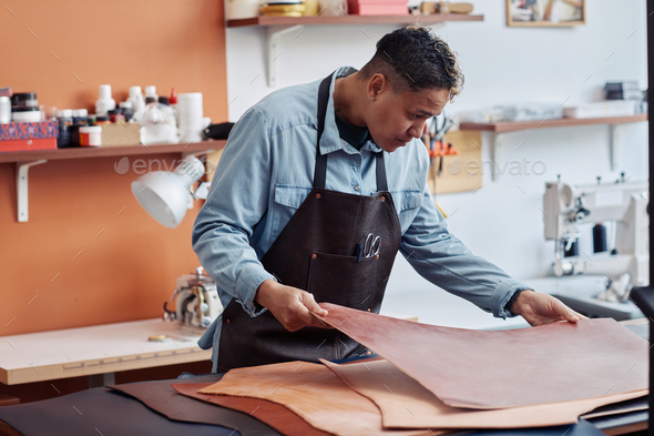 Female Artisan In Leatherworking Workshop Stock Photo by seventyfourimages