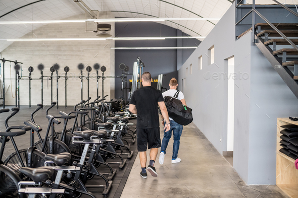 Two sportive man indoors gym with duffel bag walking locker room Stock ...