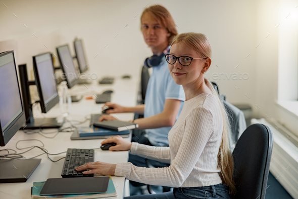 Focused university student using computer studying in computer room and ...