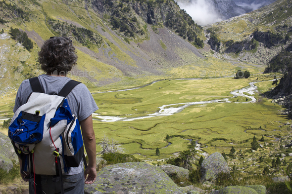 traveler observes a humid valley over a rock Stock Photo by ...