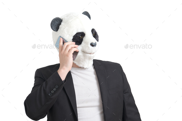 Man wearing a panda mask head and a suit speaking on the smartphone ...