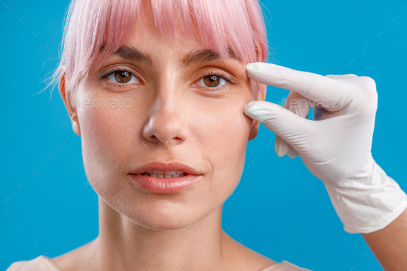 Hand of beautician touching female face, examining it before giving ...