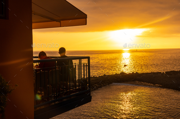 Sunset in Ponta do Sol, Madeira, a family having dinner on the beach in ...