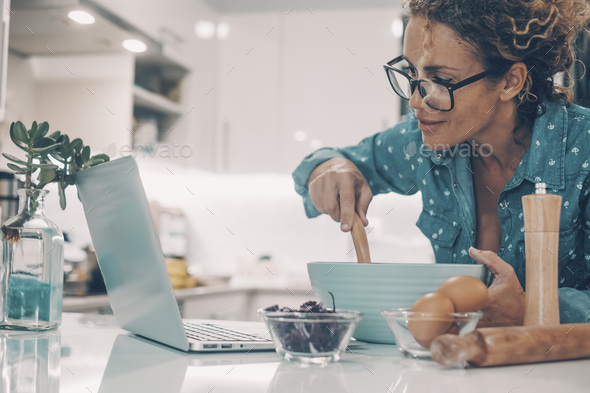 Modern wife prepare breakfast or lunch using computer and online ...