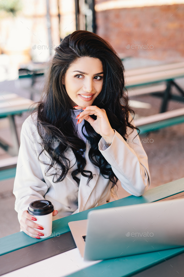 female freelancer with long wavy hair having dark eyes and healthy skin ...