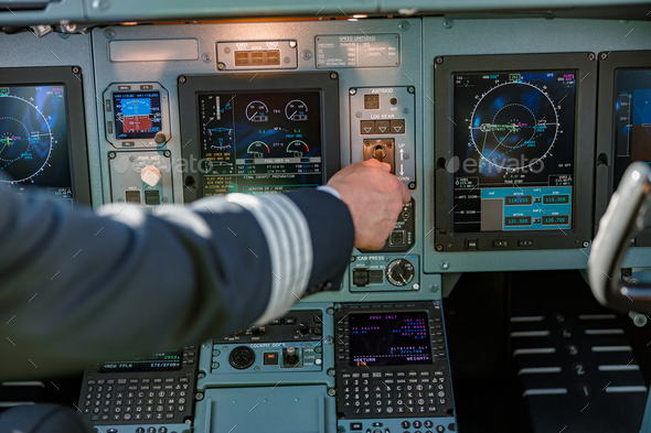 Airline pilot using control panel in aircraft cockpit Stock Photo by ...