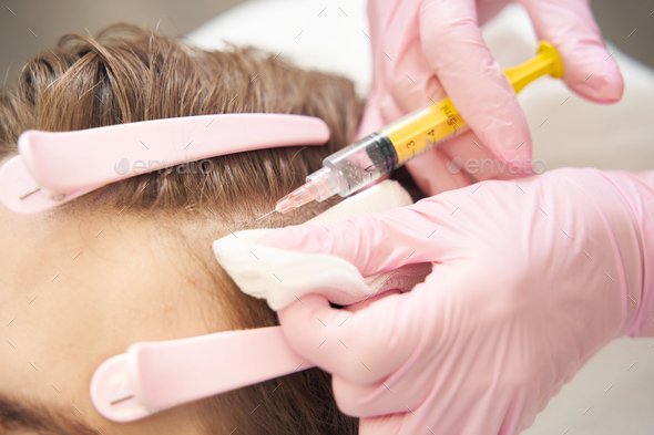 Syringe with injection pricking forehead during beauty procedure Stock ...