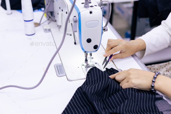 Tailor working on electric sewing machine Stock Photo by collab_media