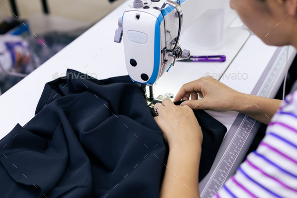 Tailor working on electric sewing machine Stock Photo by collab_media