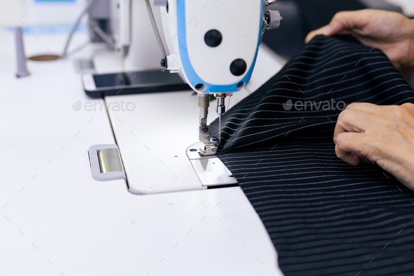 Tailor working on electric sewing machine Stock Photo by collab_media