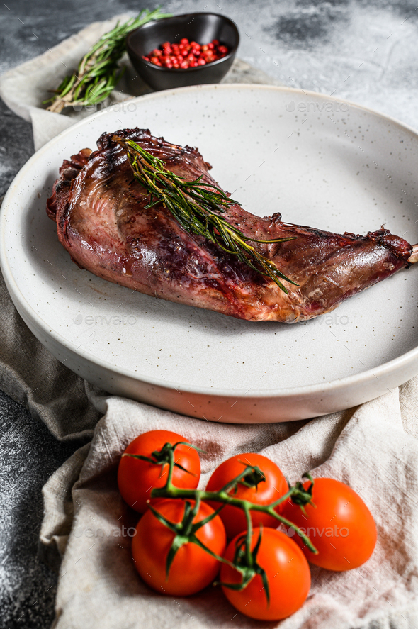 Baked rabbit leg with herbs, served on textile napkin. Organic farm ...