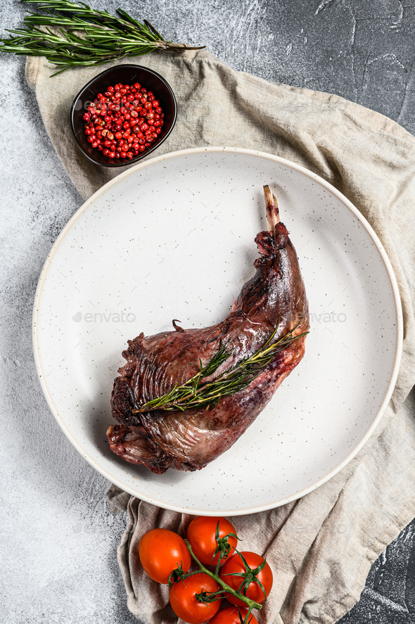Baked rabbit leg with herbs, served on textile napkin. Organic farm ...