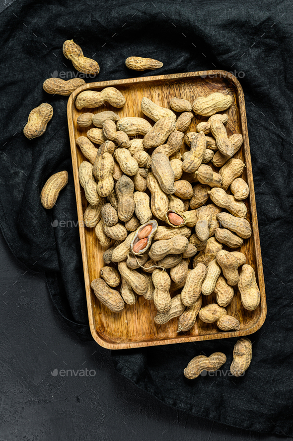 Raw unshelled peanuts in the shell. Organic groundnut. Black background ...
