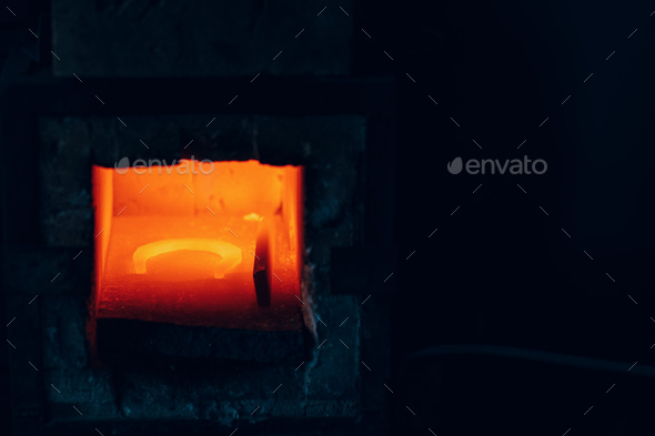 Blacksmith forge oven with hot flame. Smith heating iron piece of steel ...