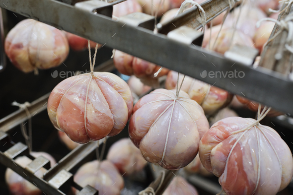 raw unprocessed pork delicacy of round shape hanging on a rope in a ...