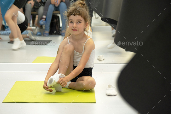 Child trains in gym on the mat, does stretching exercises and abs ...