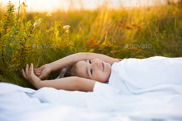 Girl sleeps on bed in grass, Sweet stretches and yawns sleepily Stock ...