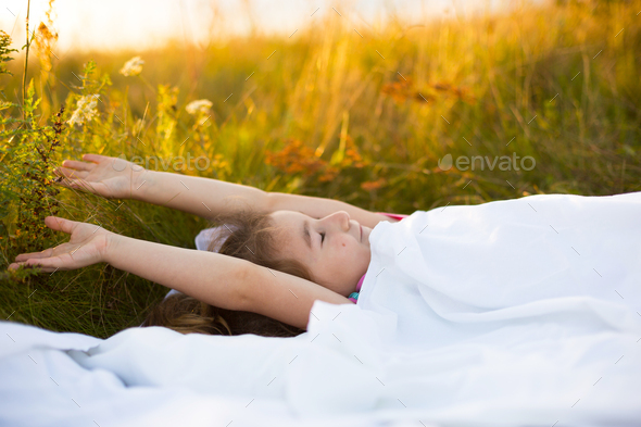 Girl sleeps on bed in grass, Sweet stretches and yawns sleepily Stock ...
