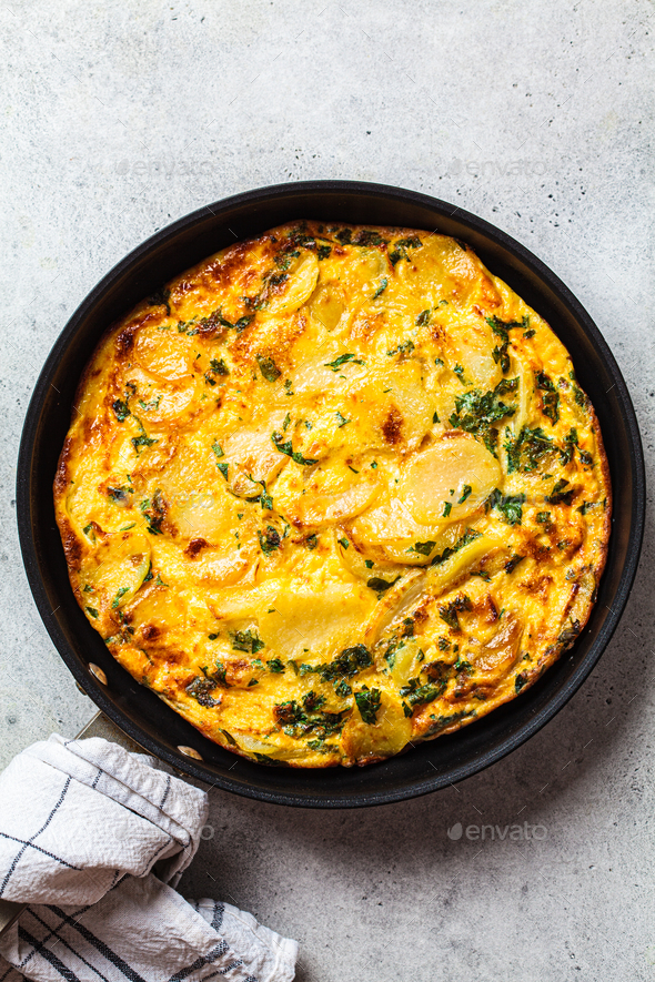 Traditional Spanish potato tortilla or omelette in black pan. Stock ...