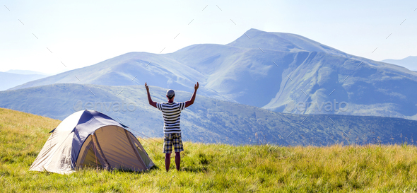 Hiker meets good morning with raised hands just got out from tent in ...
