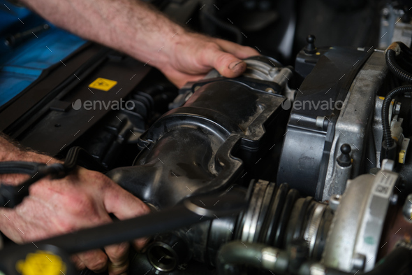 Car mechanic hands replacing engine throttle body. Stock Photo by Ladanifer