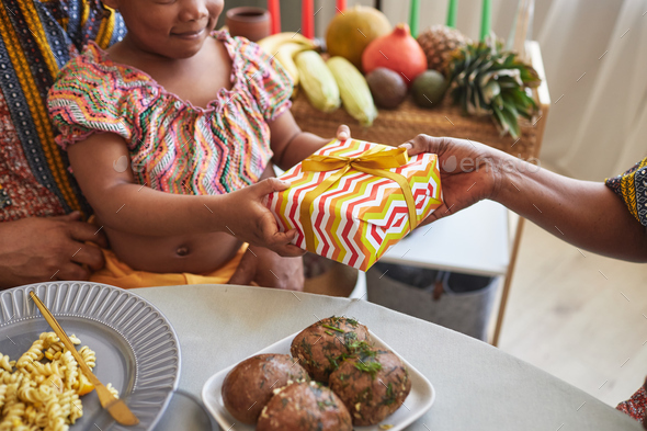 Little girl getting present from parents Stock Photo by seventyfourimages
